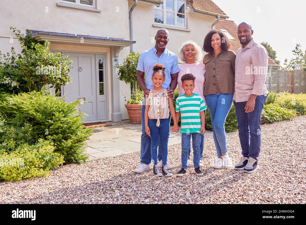 Portrait Of Smiling Multi-Generation Family Standing Outside Home ...