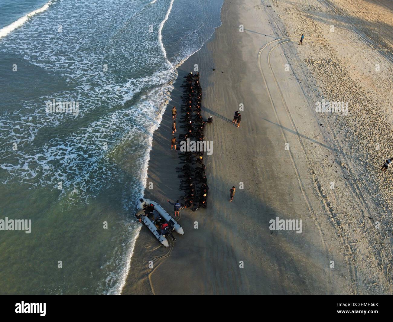 Aerial view of the people waiting at the beach for their turn in line ...