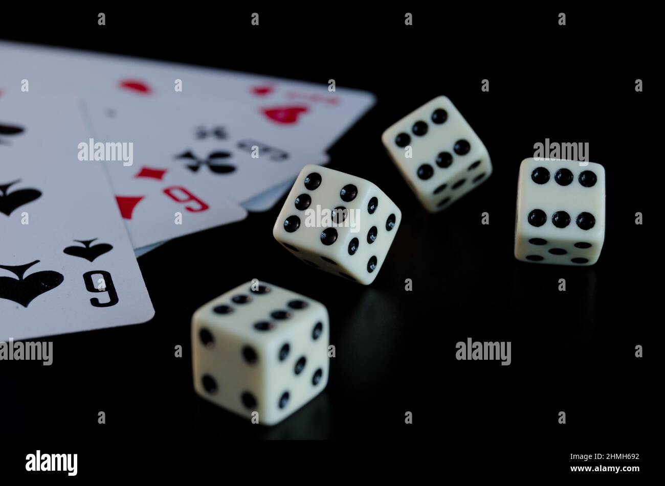 Dice, playing cards on a black background thrown on the table Stock ...