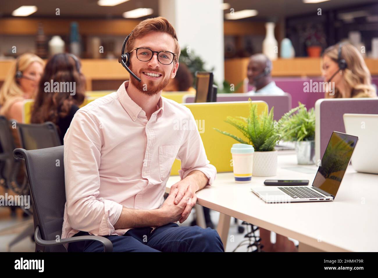 Portrait Of Businessman Wearing Headset Talking To Caller In Customer ...