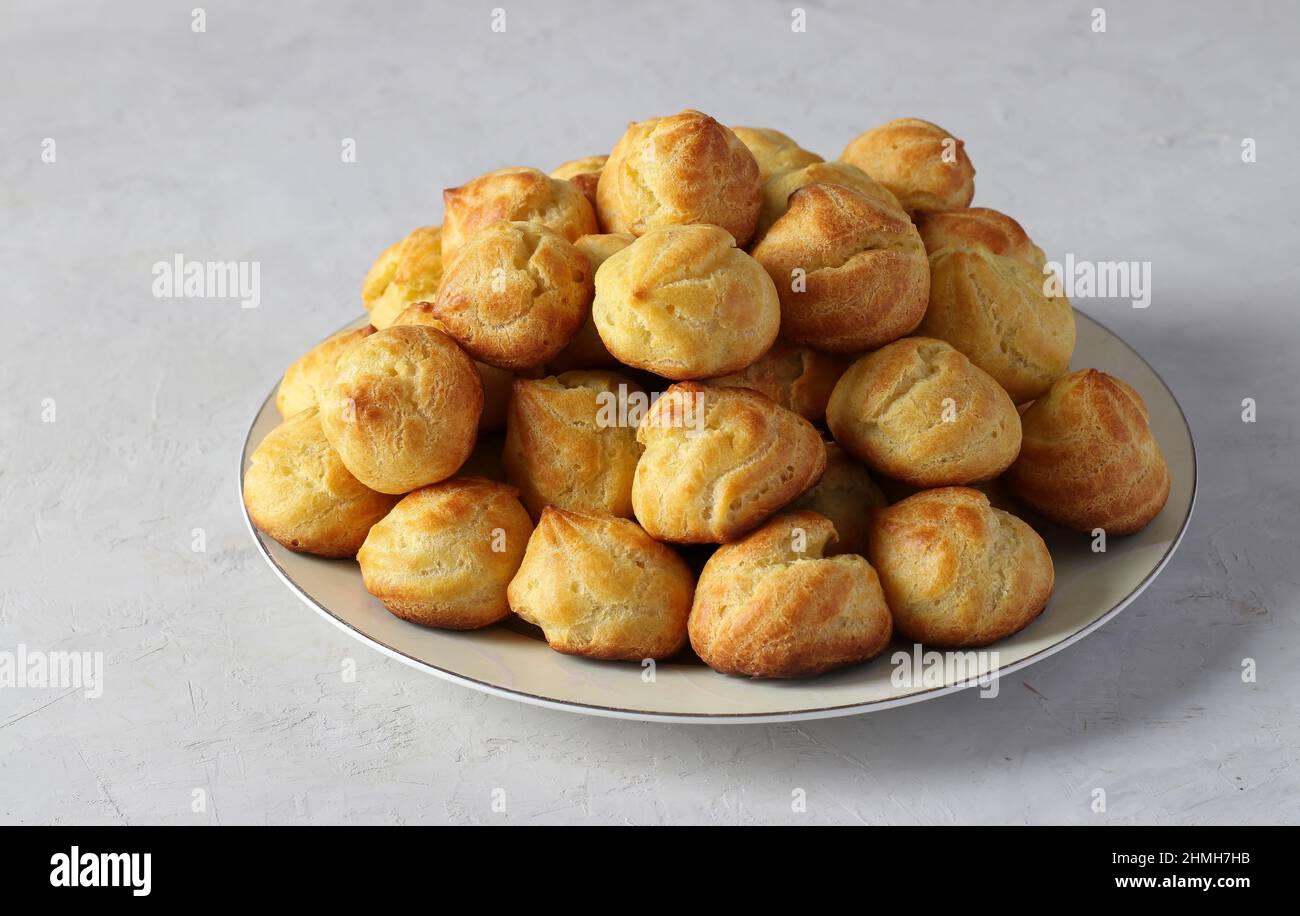 Baked profiteroles from puff pastry, choux pastry balls on a gray ...