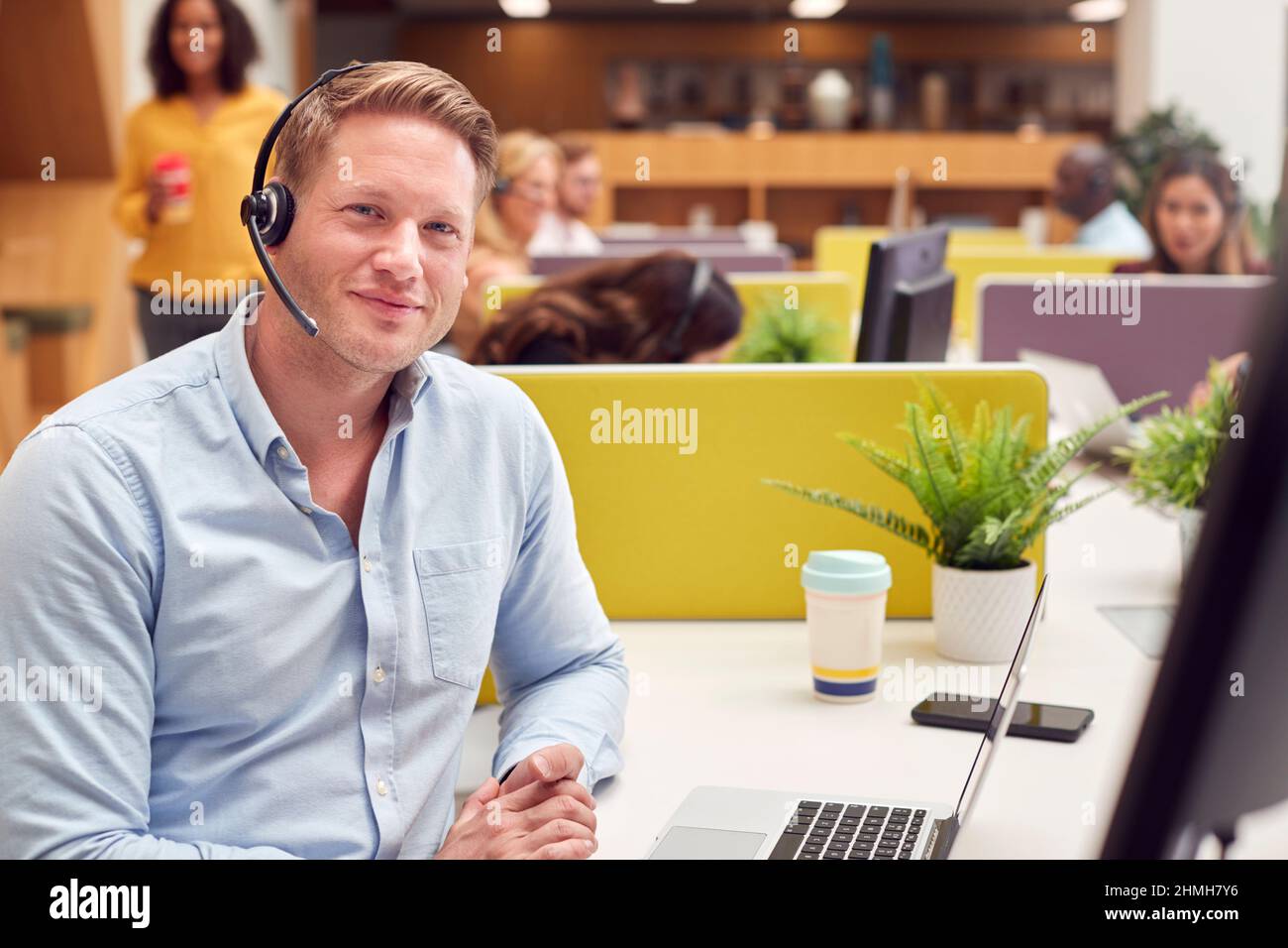 Portrait Of Businessman Wearing Headset Talking To Caller In Busy ...