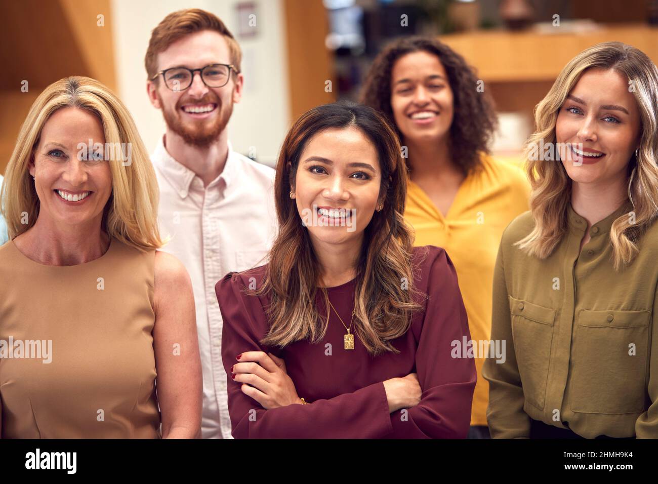 Portrait Of Smiling Multi-Cultural Business Team Standing In Modern ...