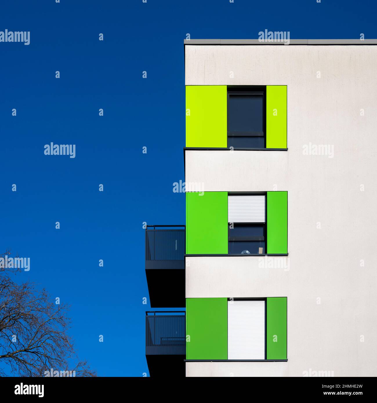 Commercial building, green windows, blue sky Stock Photo - Alamy