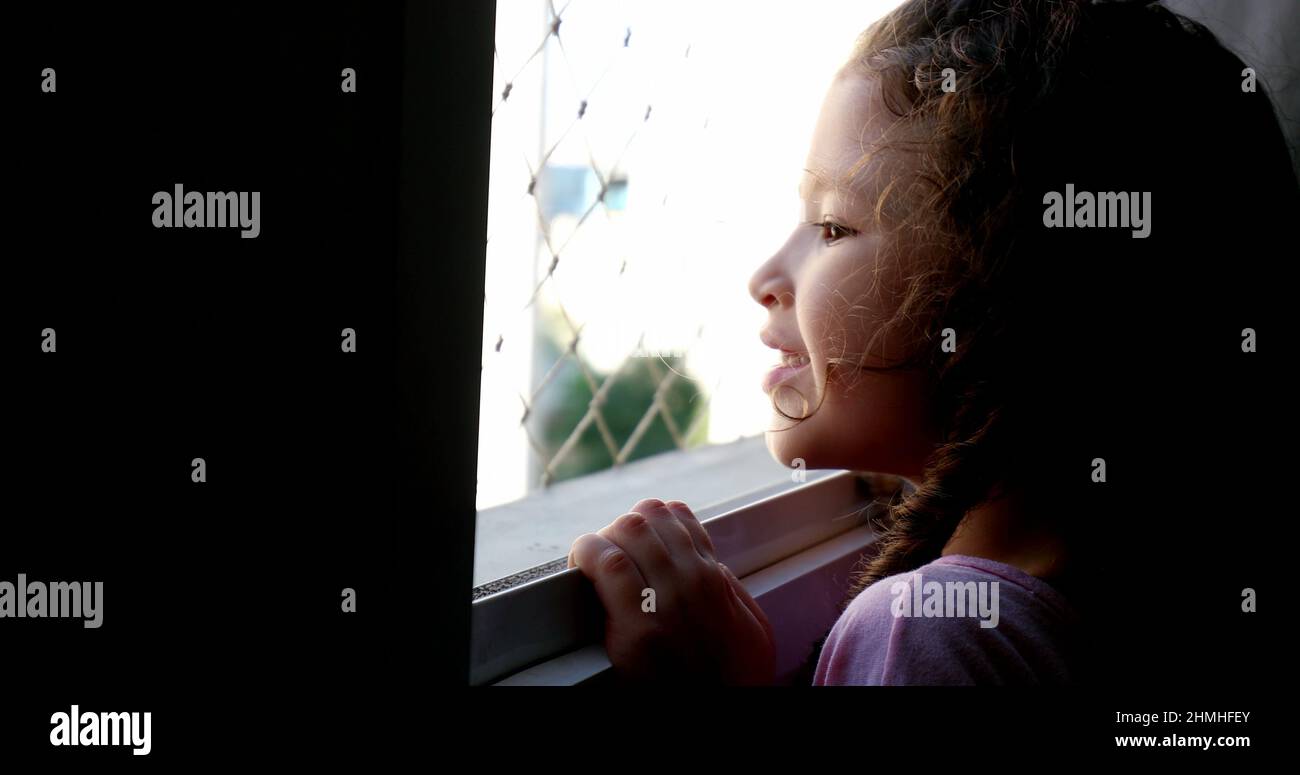 Child girl looking outside through window, kid peeking head out Stock ...