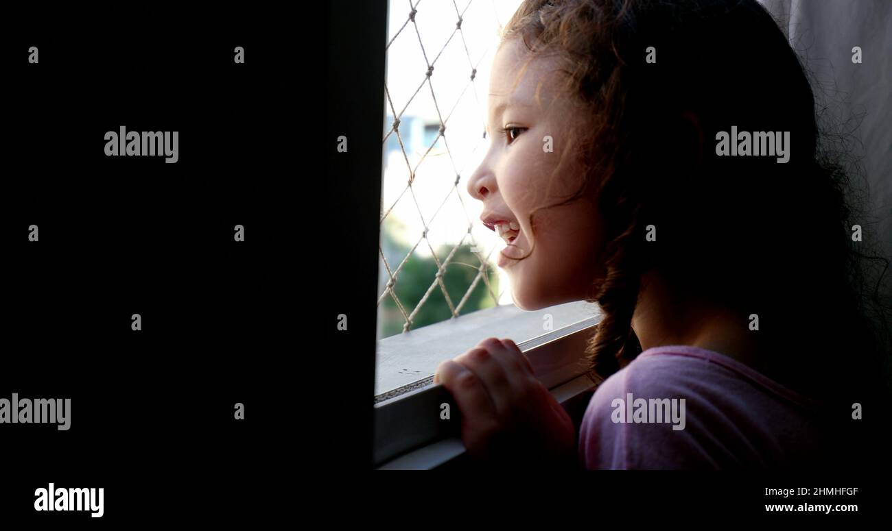 Child girl looking outside through window, kid peeking head out Stock ...