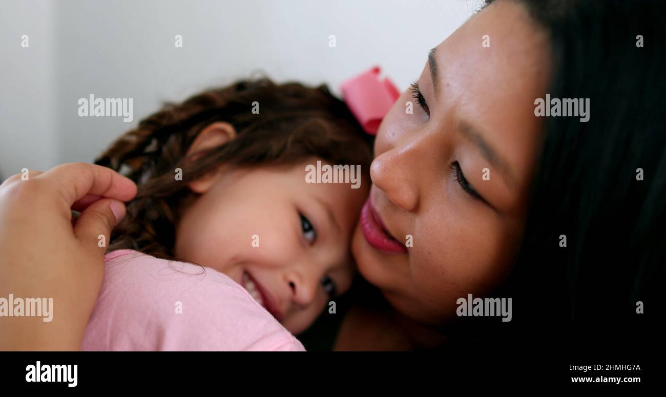 Cute little girl hugging and loving mom. Candid authentic affection and ...