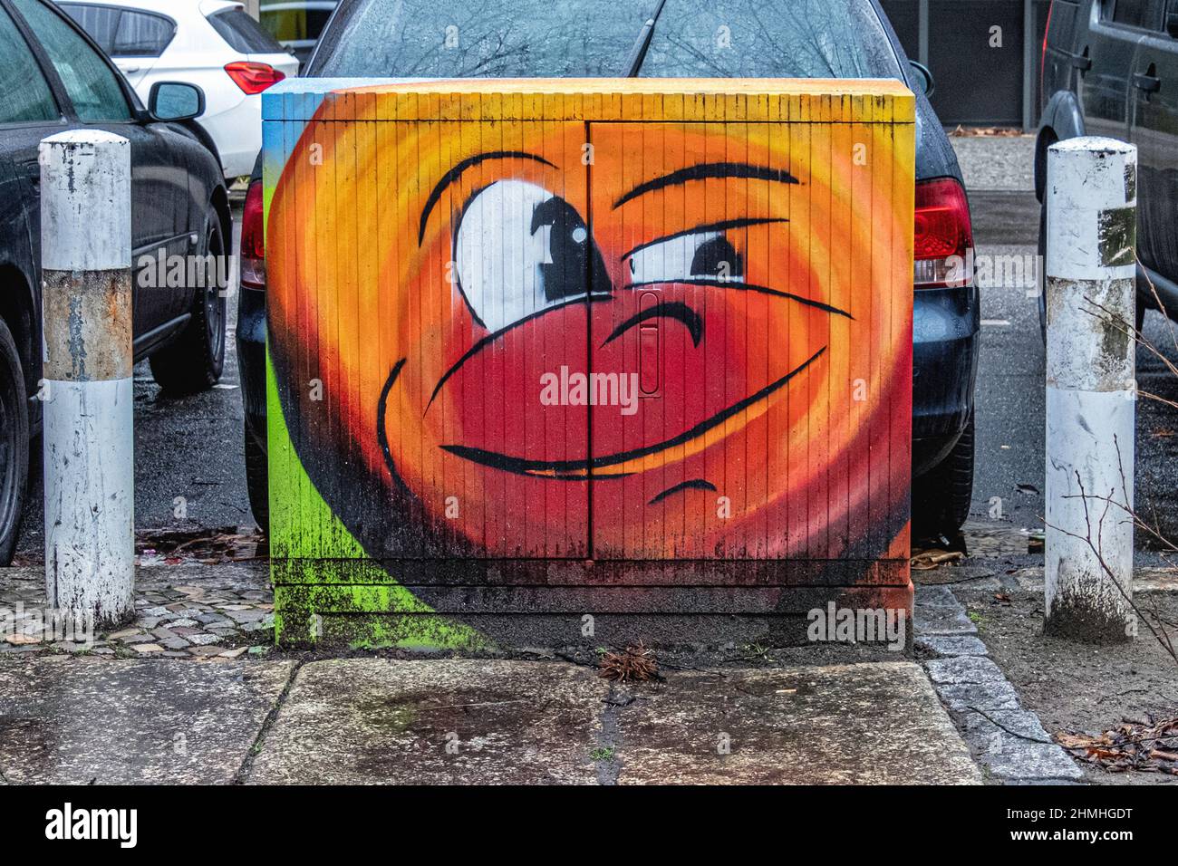 Painting of orange winking emoji. Artwork on utility box in Mitte ...