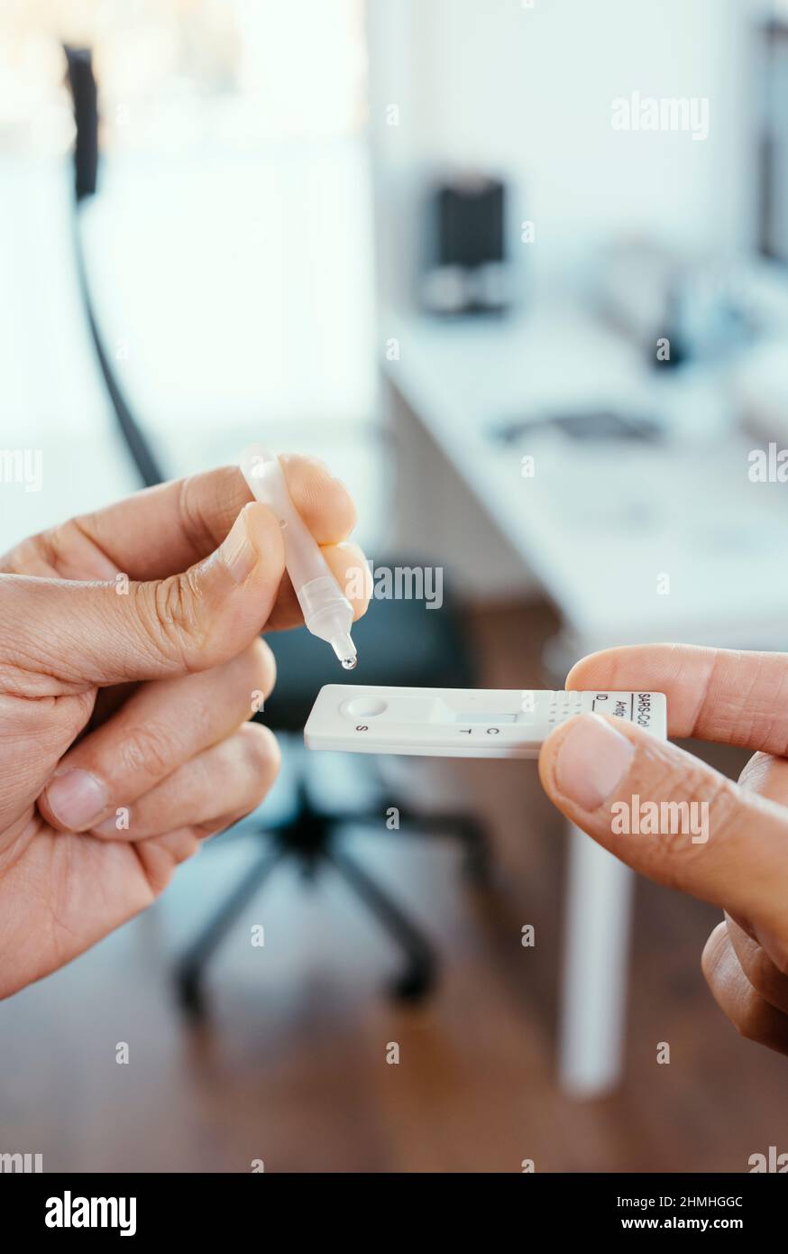 a young man is placing his own sample into the covid-19 antigen ...