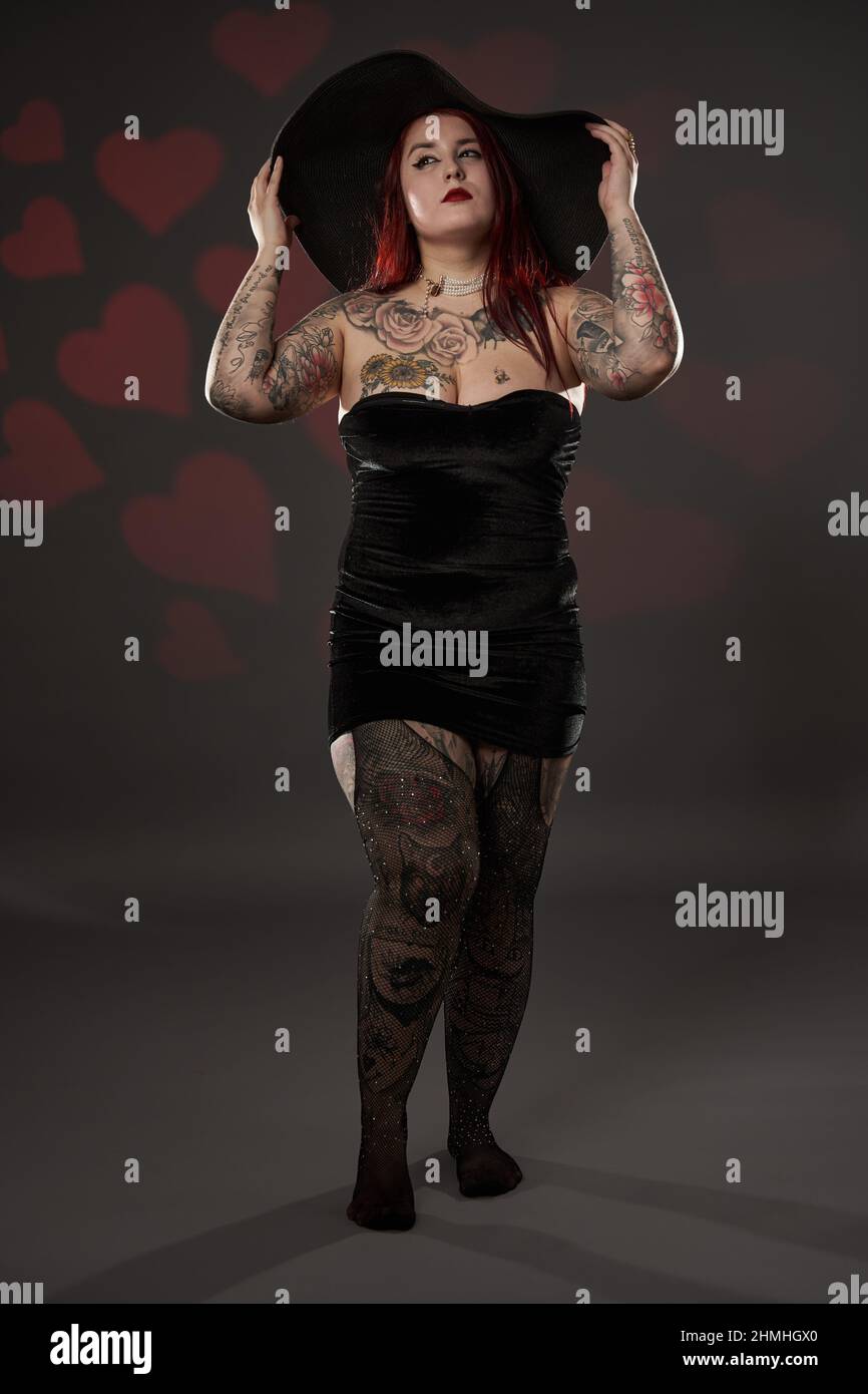 Beautiful size plus woman with tattoos in black mini dress ...