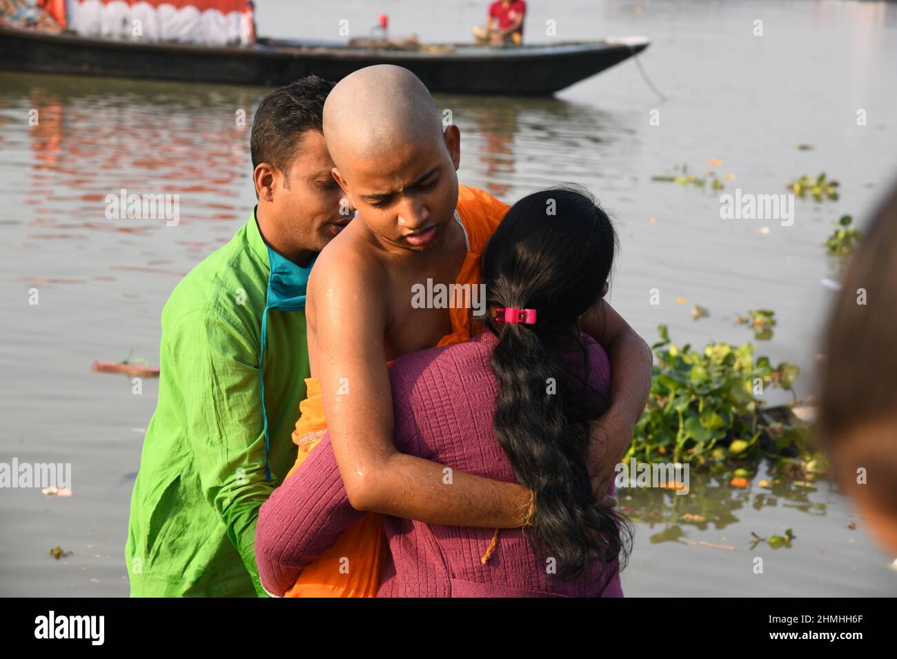 A Hindu Brahmin boy hugs his parents after dip in the Ganges at the end ...