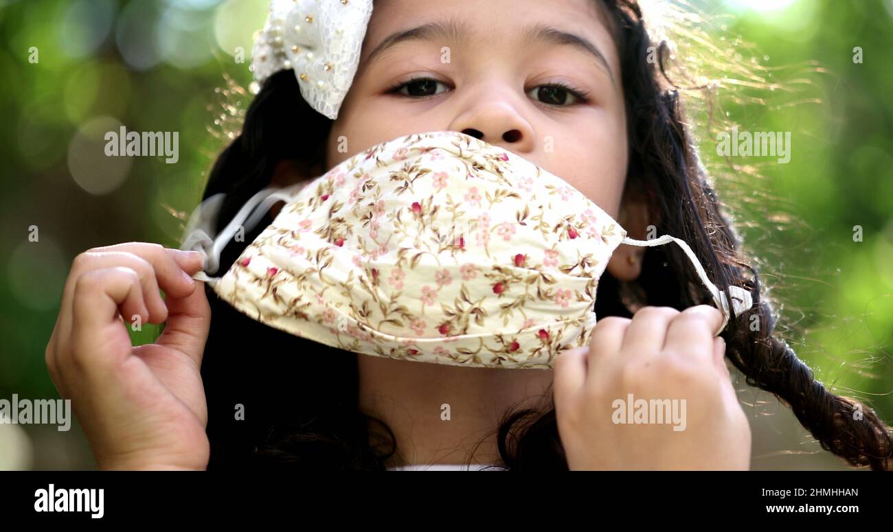 Little girl child removes face mask feeling relief, taking a deep ...