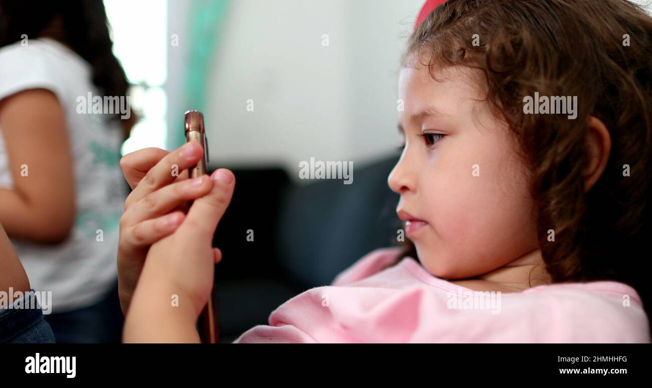 Little girl watching social media on cellphone Stock Photo - Alamy