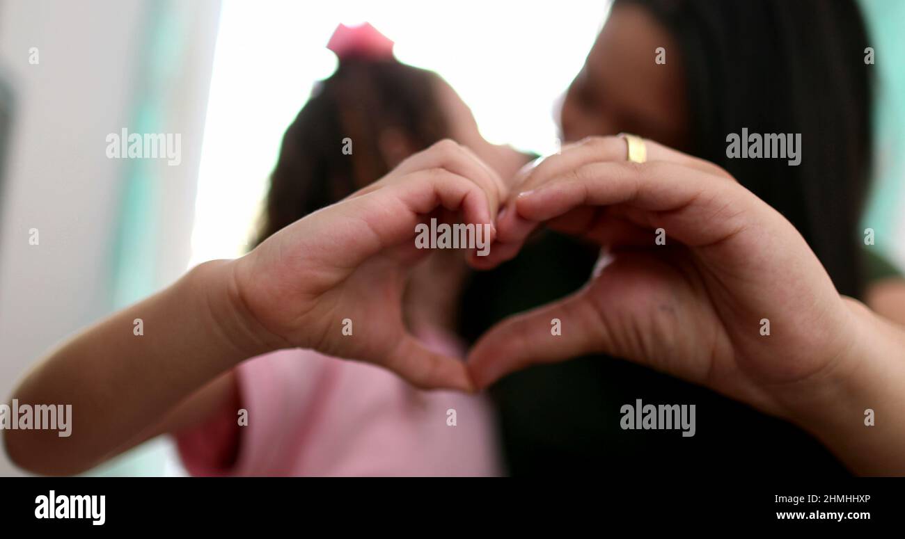 Mother and child doing heart symbol sign with hands Stock Photo - Alamy