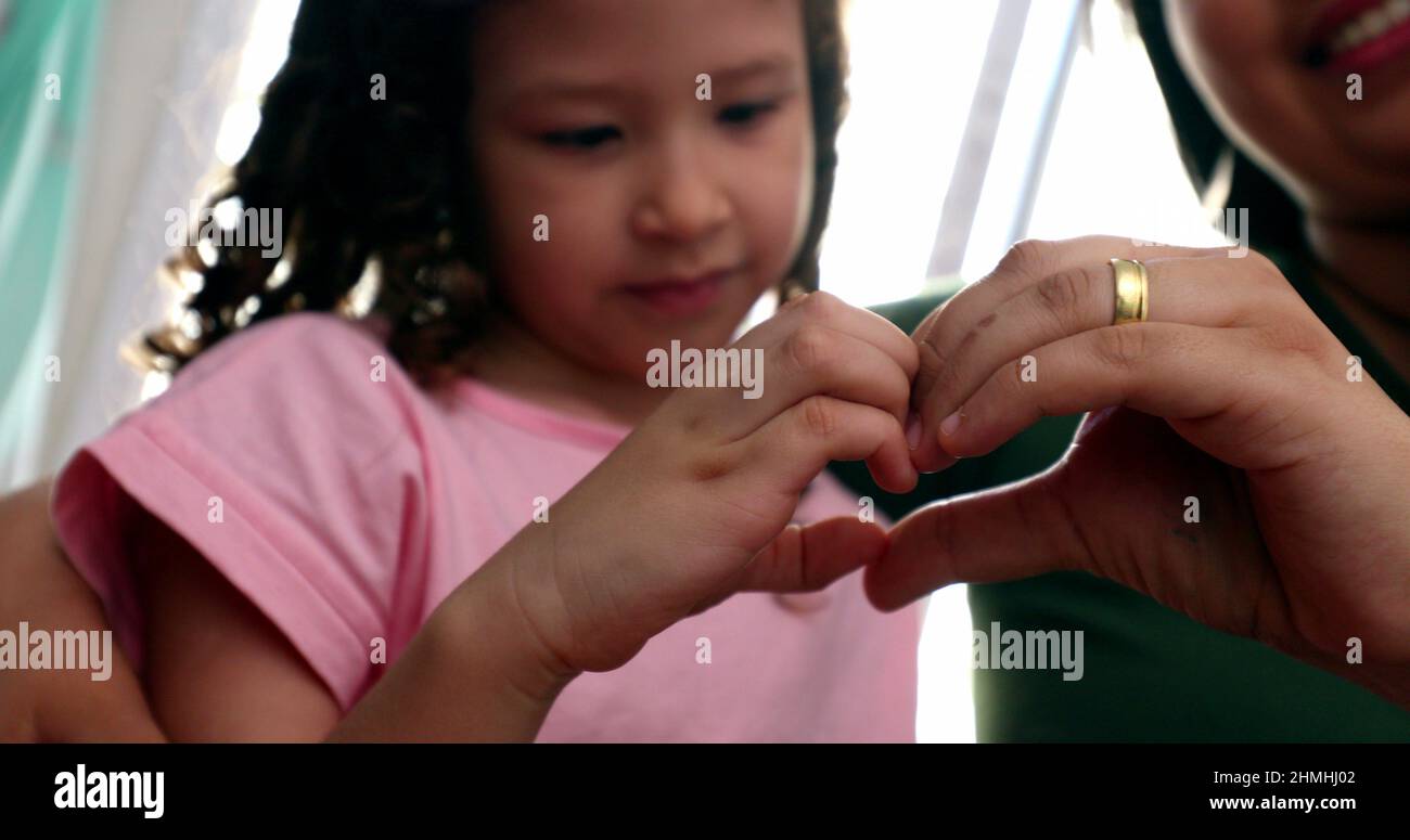 Mother and child girl doing heart sign symbol with hands Stock Photo ...