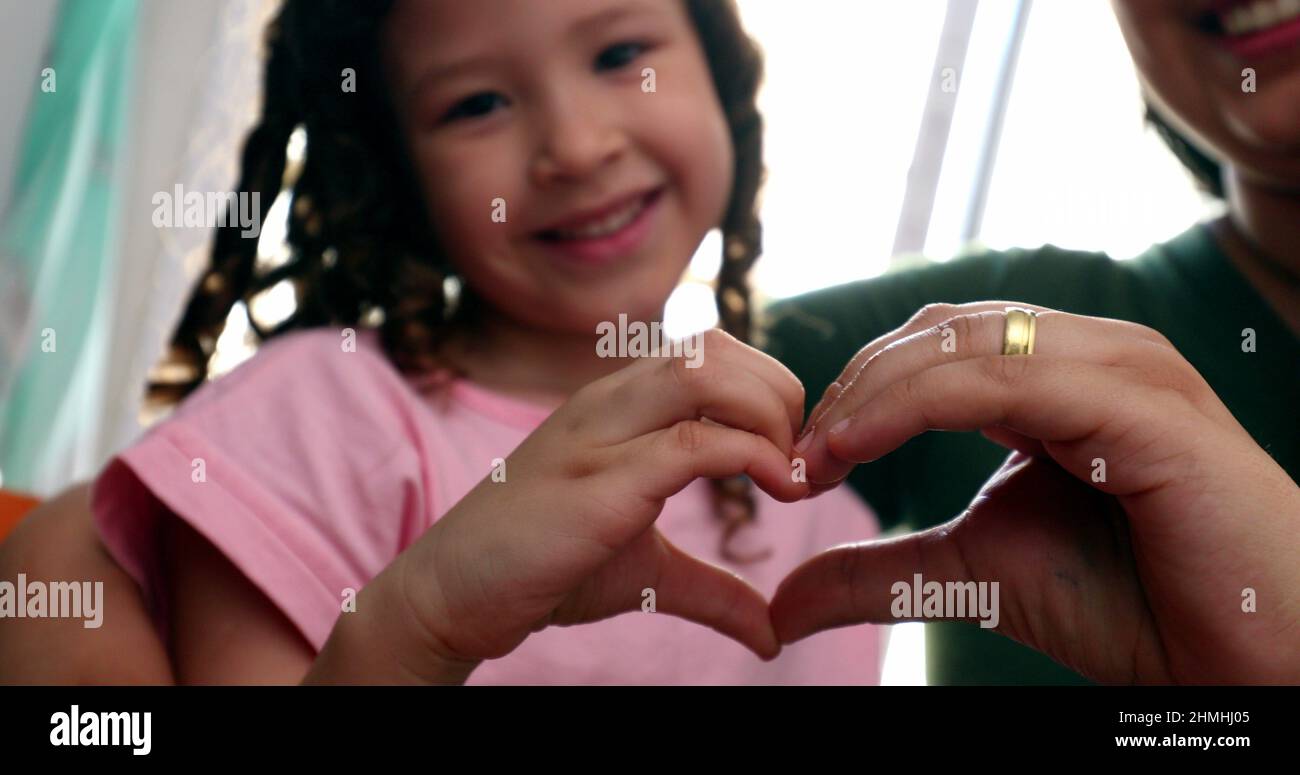 Mother and child girl doing heart sign symbol with hands Stock Photo ...
