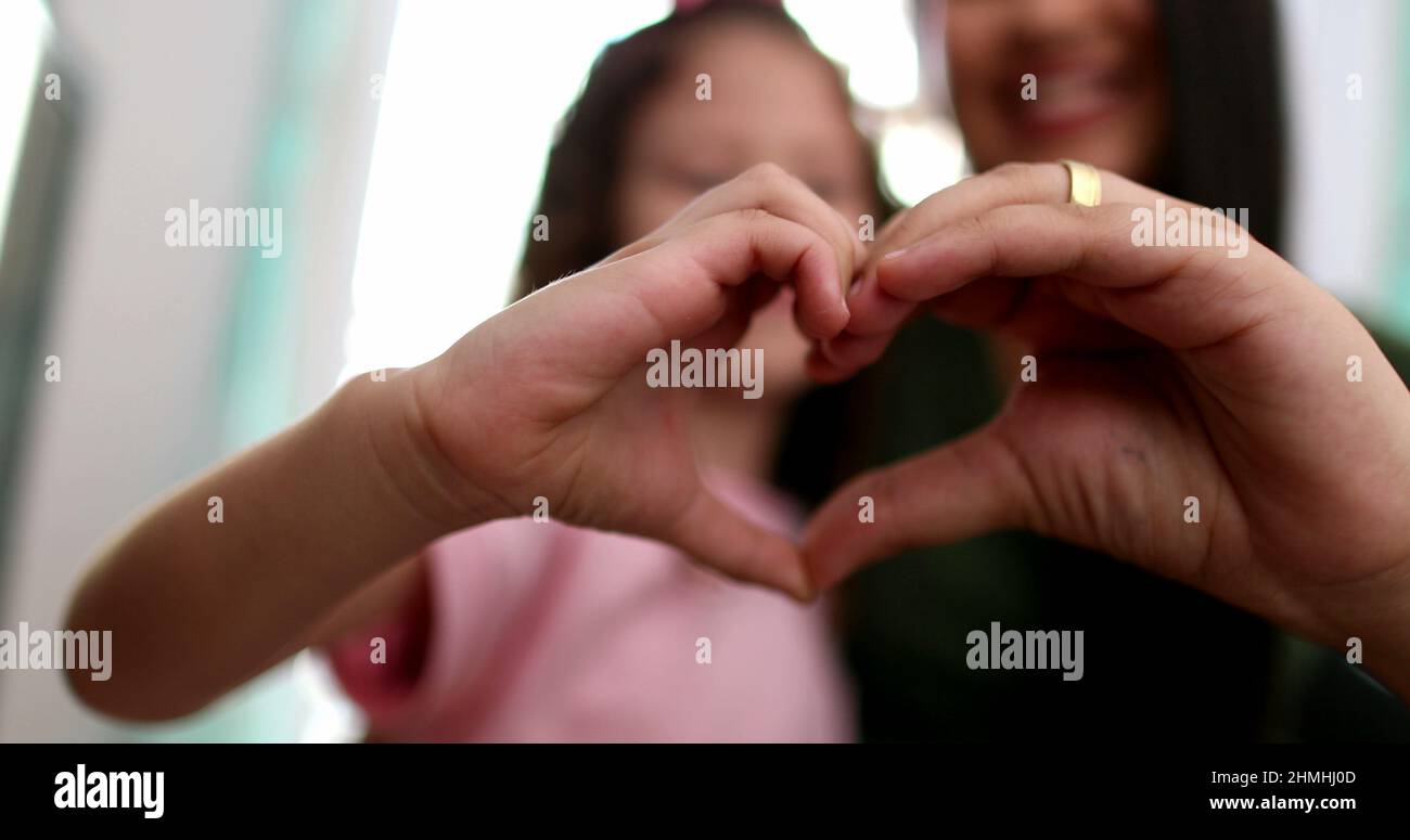 Mother and child girl doing heart sign symbol with hands Stock Photo ...