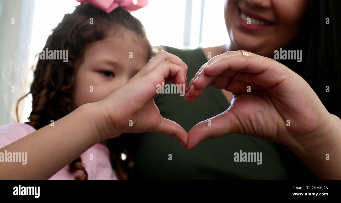 Mother and child girl doing heart sign symbol with hands Stock Photo ...
