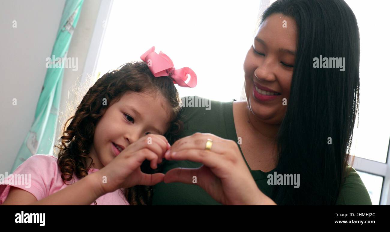 Mother and child girl doing heart sign symbol with hands Stock Photo ...
