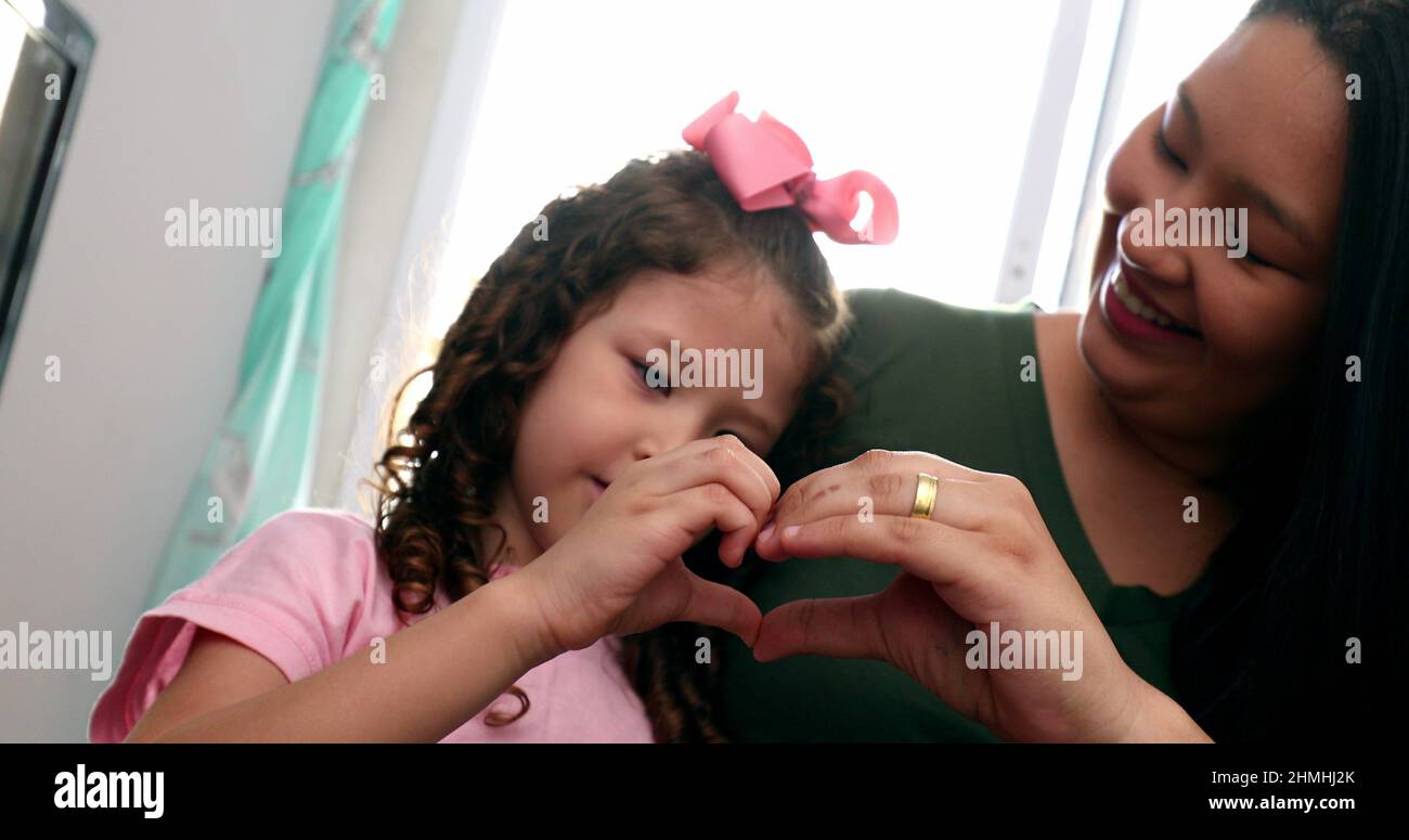 Mother and child girl doing heart sign symbol with hands Stock Photo ...