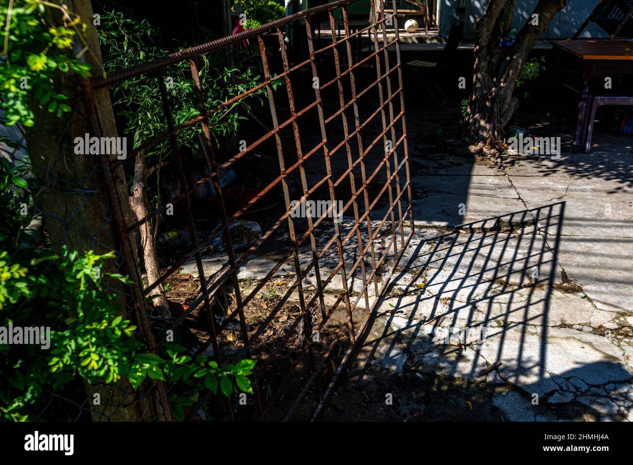 An old wire fence with a great shadow falling on the alley Stock Photo ...