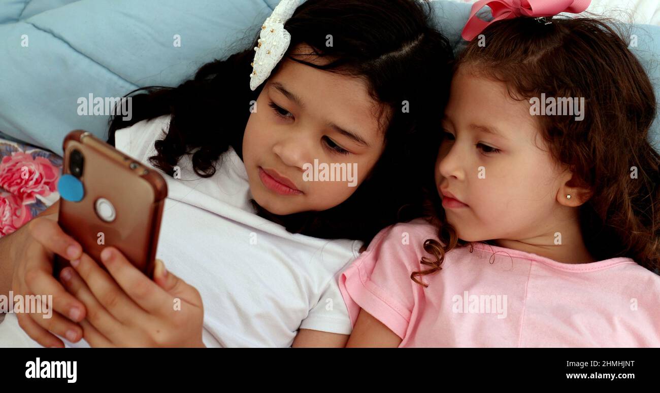 Pre-teen little girls in front of smartphone device, social media ...