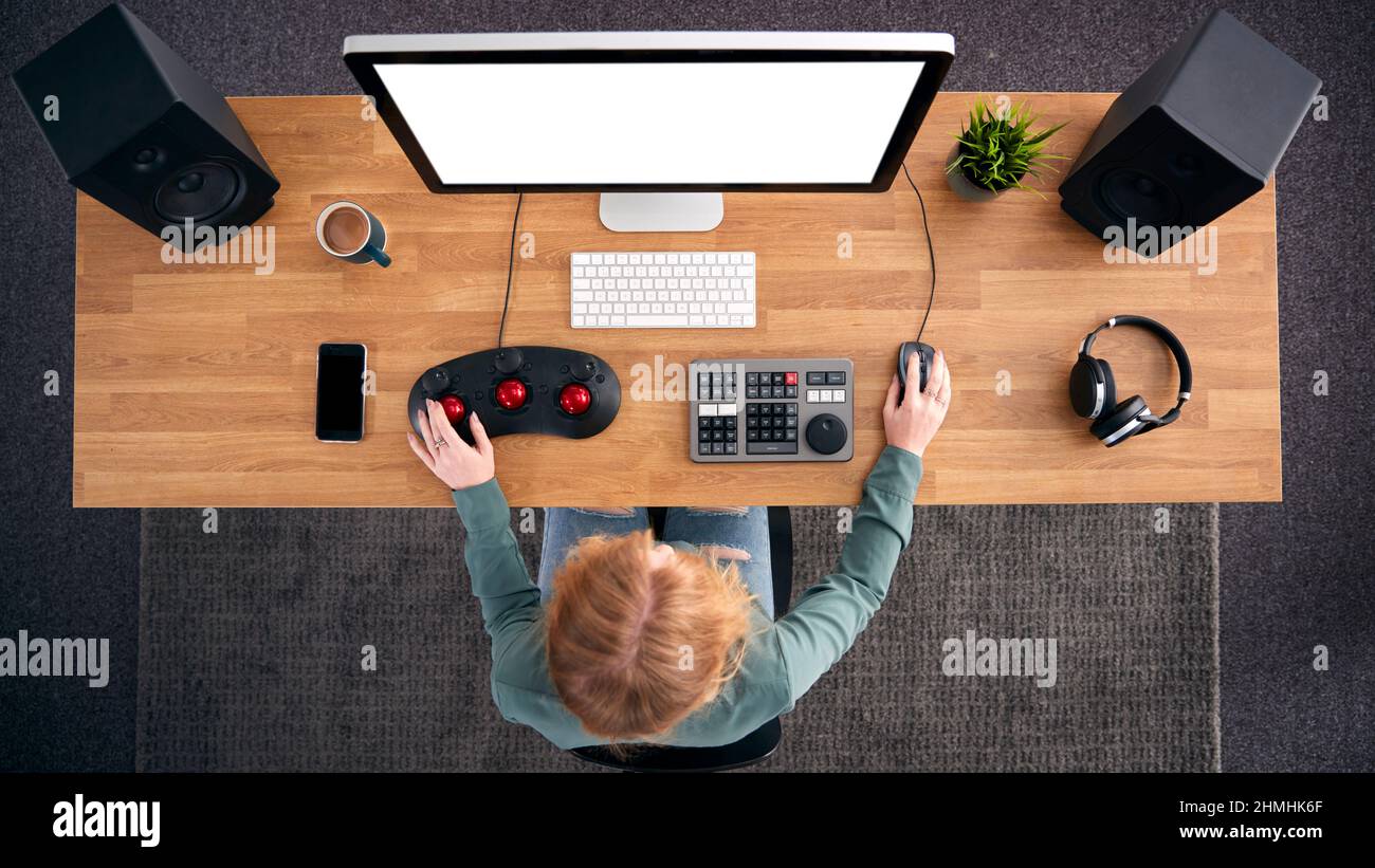Overhead View Of Female Video Editor Working At Computer In Creative ...