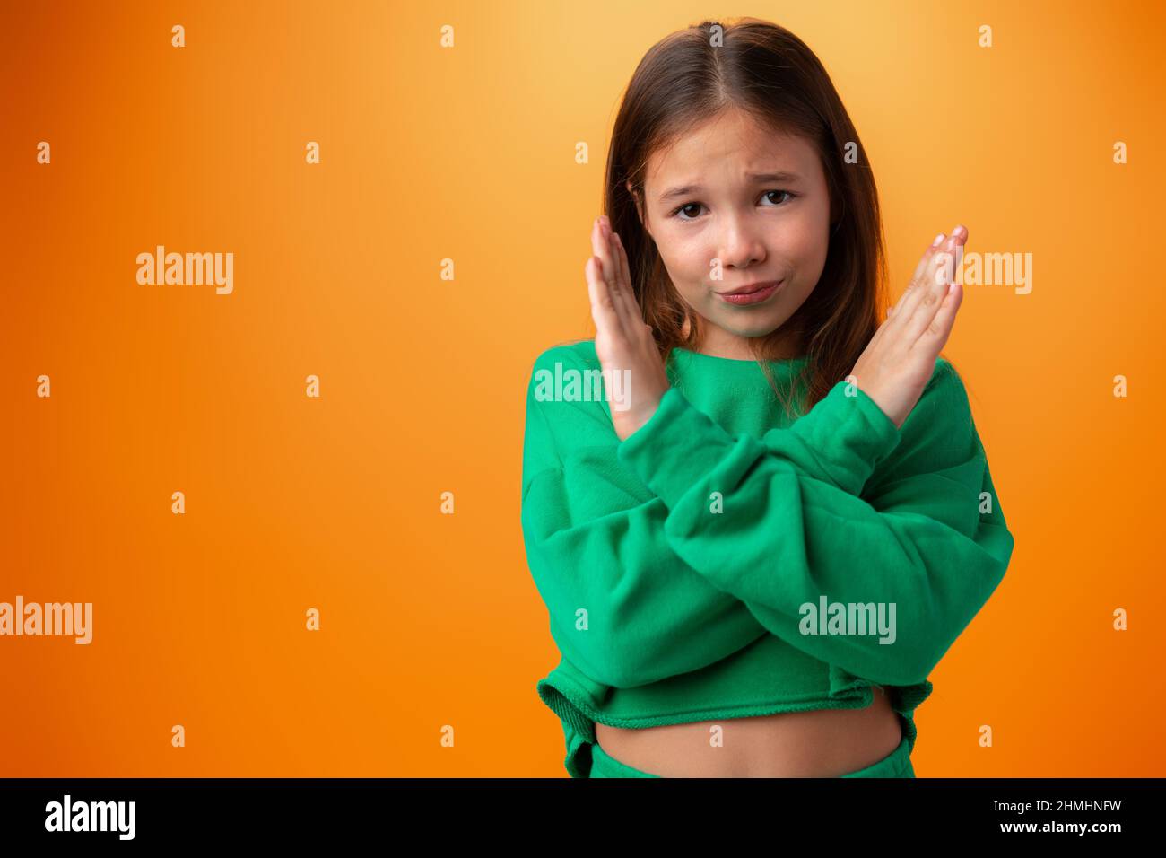 Teen girl making stop gesture on orange background Stock Photo - Alamy