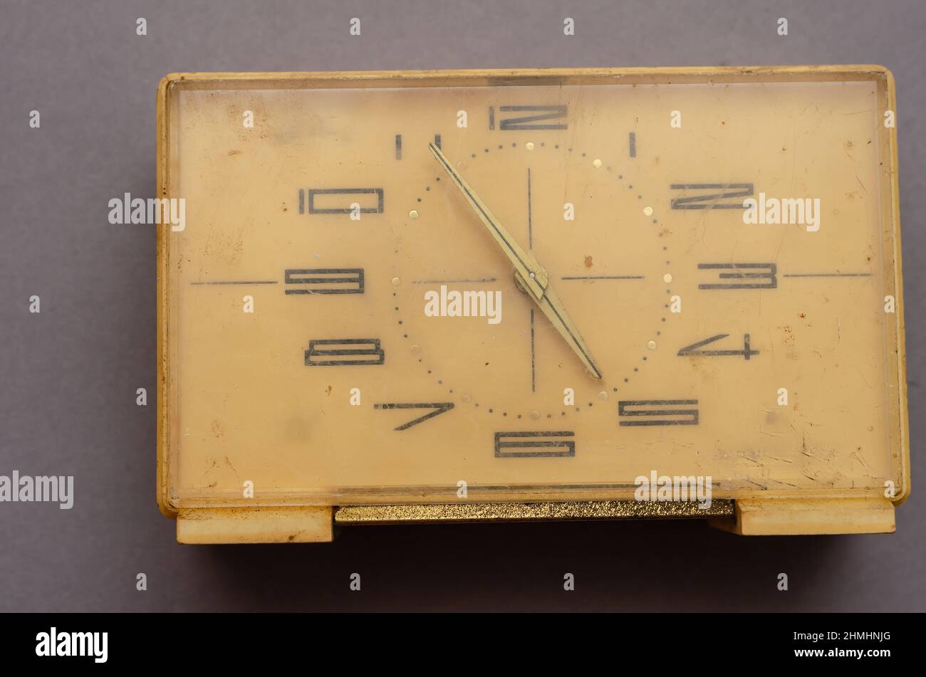 Vintage USSR. An old plastic yellow alarm clock against a gray ...
