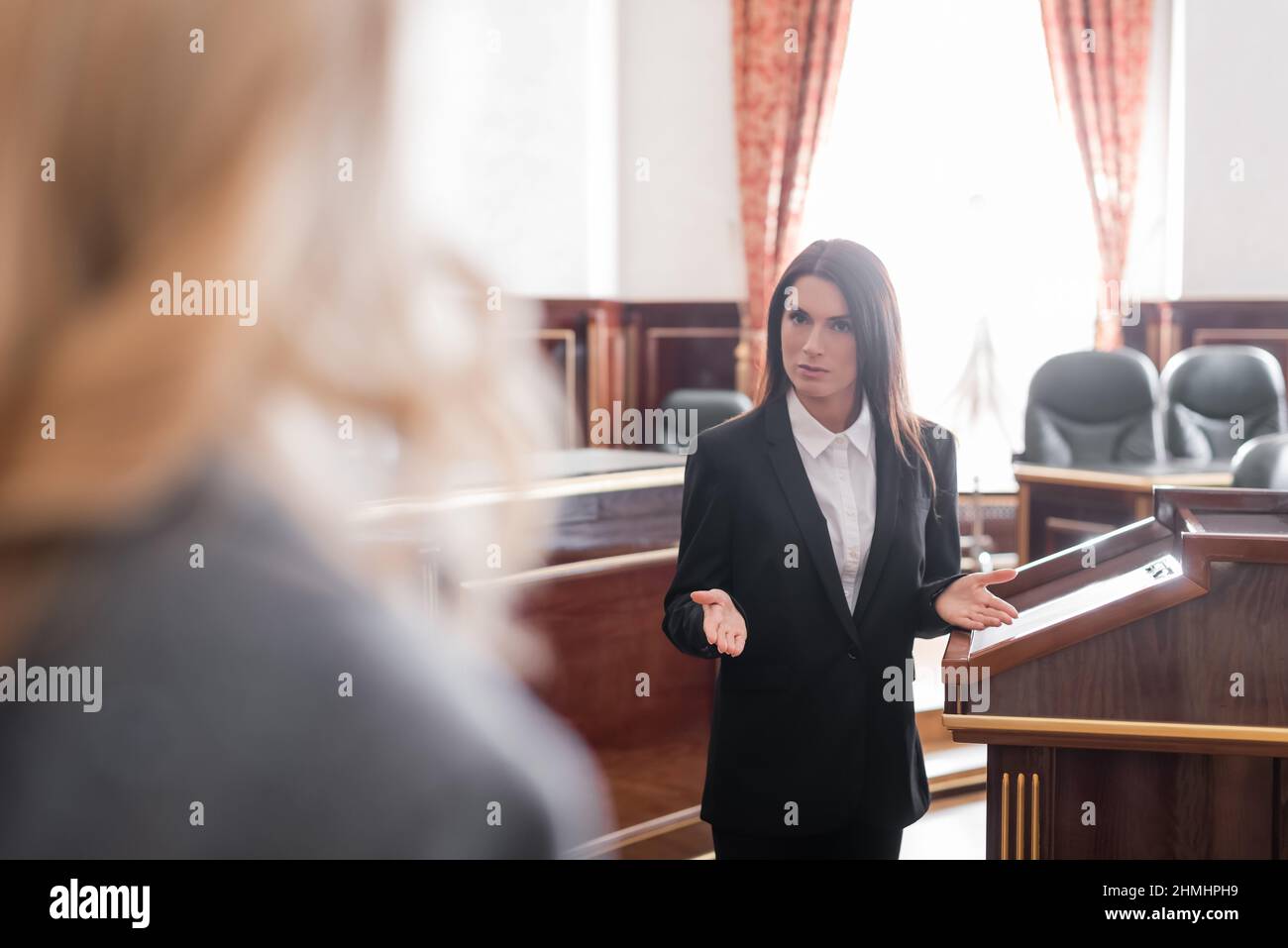 prosecutor pointing with hands while talking to blurred witness in ...