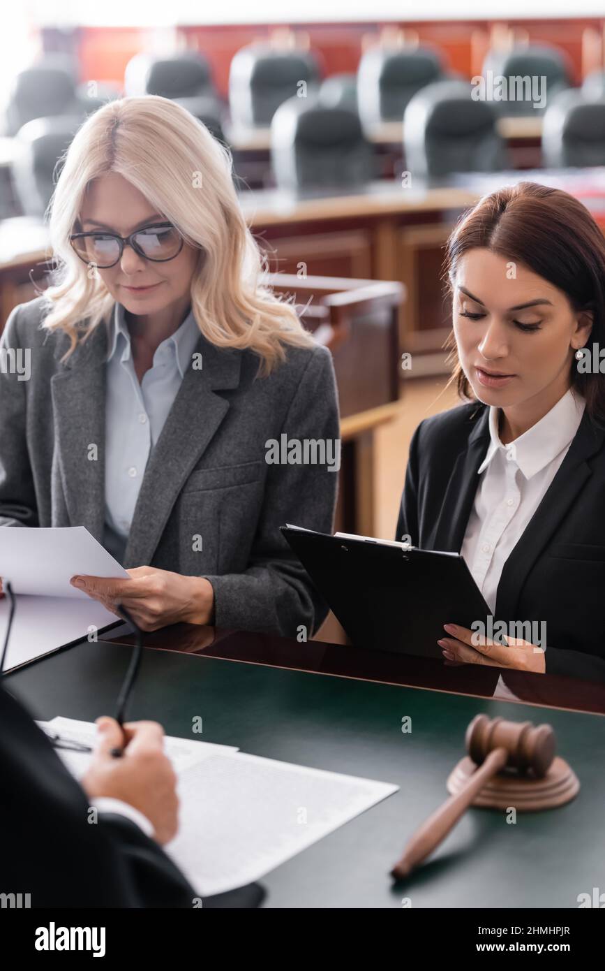 prosecutor and advocate reading documents near judge in courtroom Stock ...