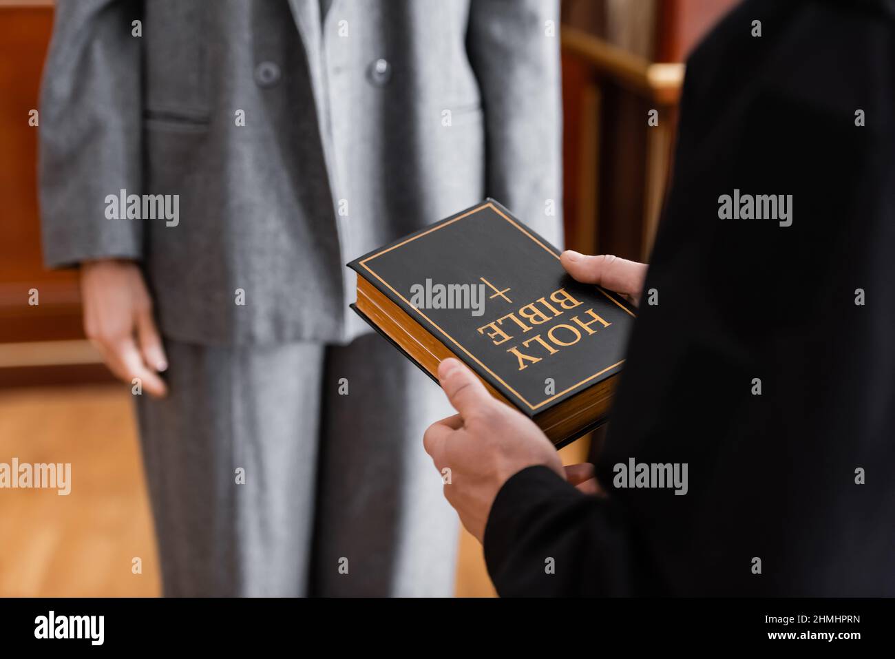 partial view of bailiff holding holy bible near woman in court Stock ...