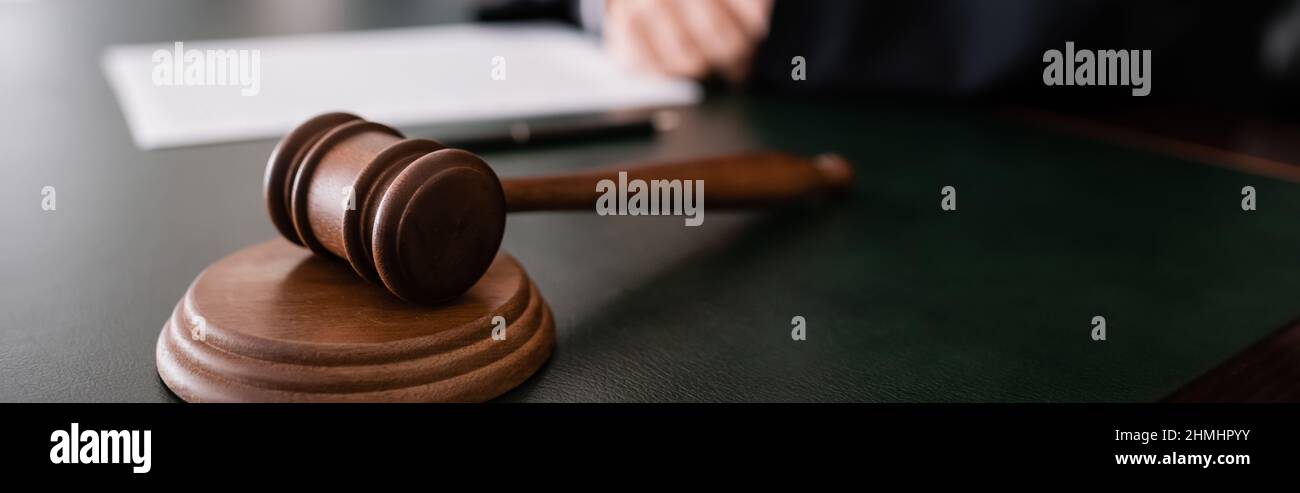 wooden gavel on desk near cropped judge on blurred background, banner ...