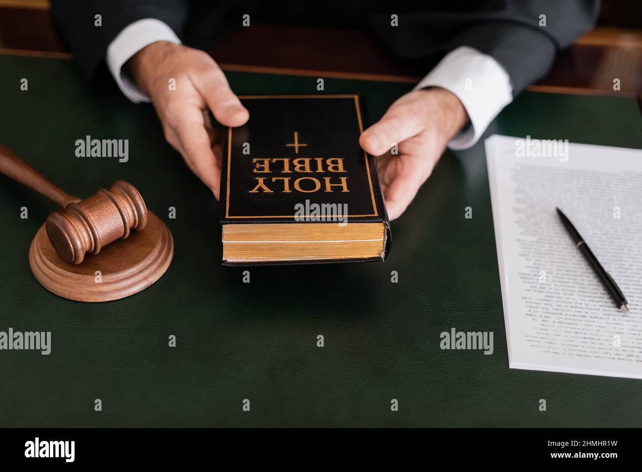 partial view of judge holding bible near gavel and lawsuit in law Stock ...