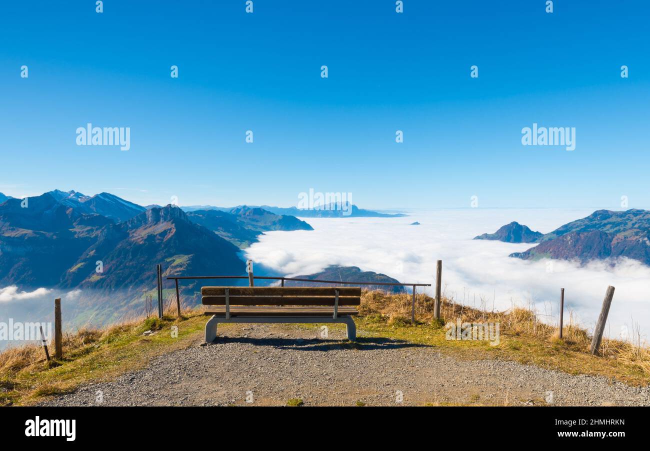 Aerial view. Peak. Bench to rest on the edge. Below clouds and a lake ...