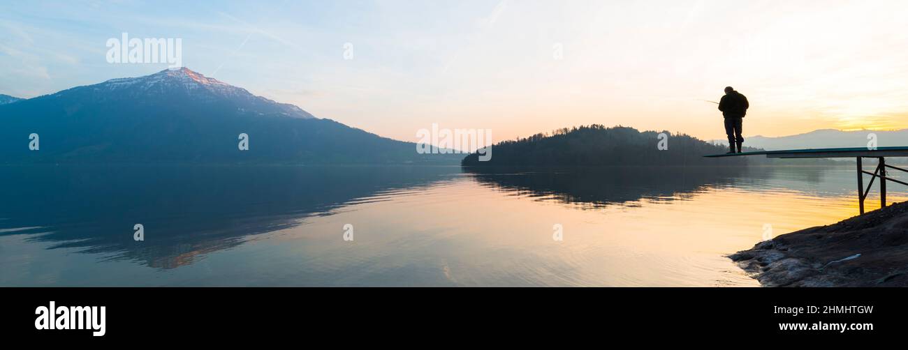 A man catches a fish. Happy relaxed hours alone with nature. Landscape ...