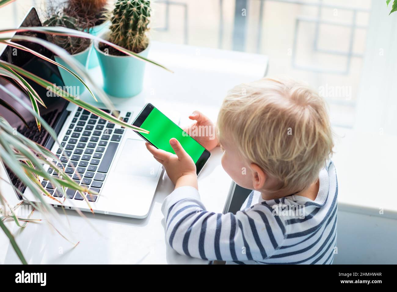 Cute baby boy watching, playing on the phone, focus on chromakey green ...