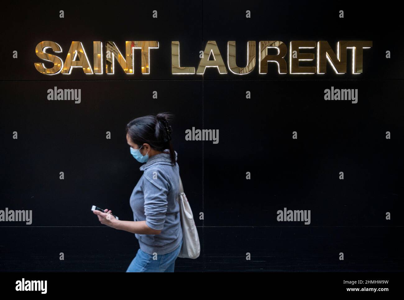 A pedestrian walks past the French luxury fashion brand Yves Saint ...