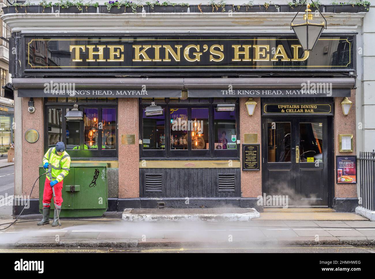 10 February 2022. Workman cleaning pavement with high pressure jet wash ...