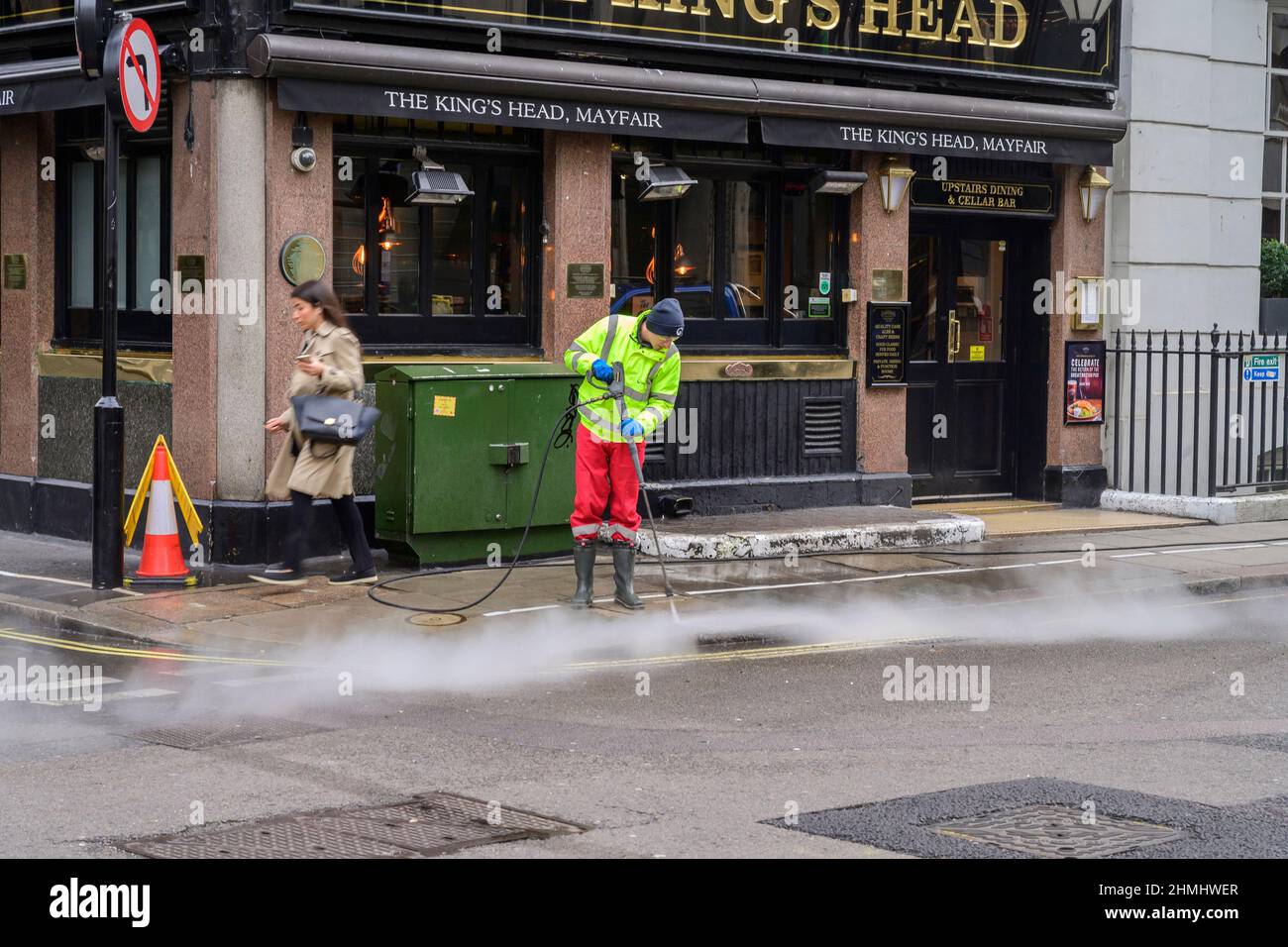 10 February 2022. Workman cleaning pavement with high pressure jet wash ...