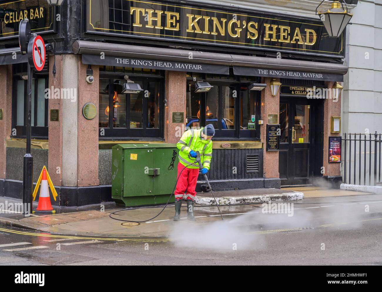 10 February 2022. Workman cleaning pavement with high pressure jet wash ...