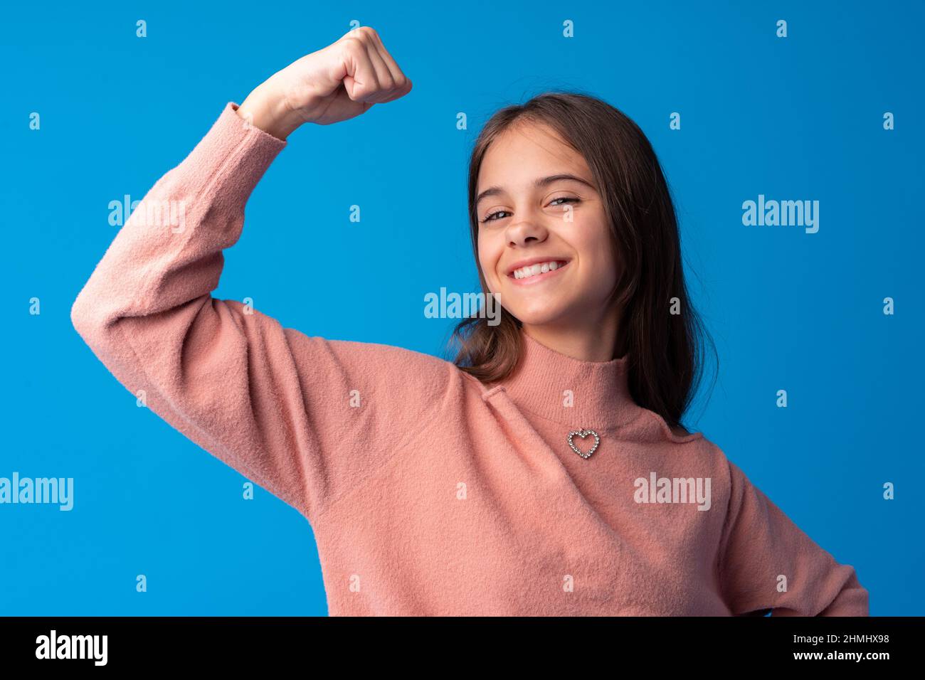 Little cute girl showing her strength on blue background Stock Photo ...