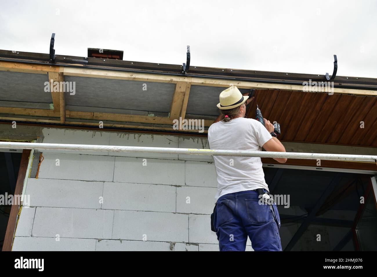 A carpenter mounts the roof ceiling on a scaffolding at height Stock ...