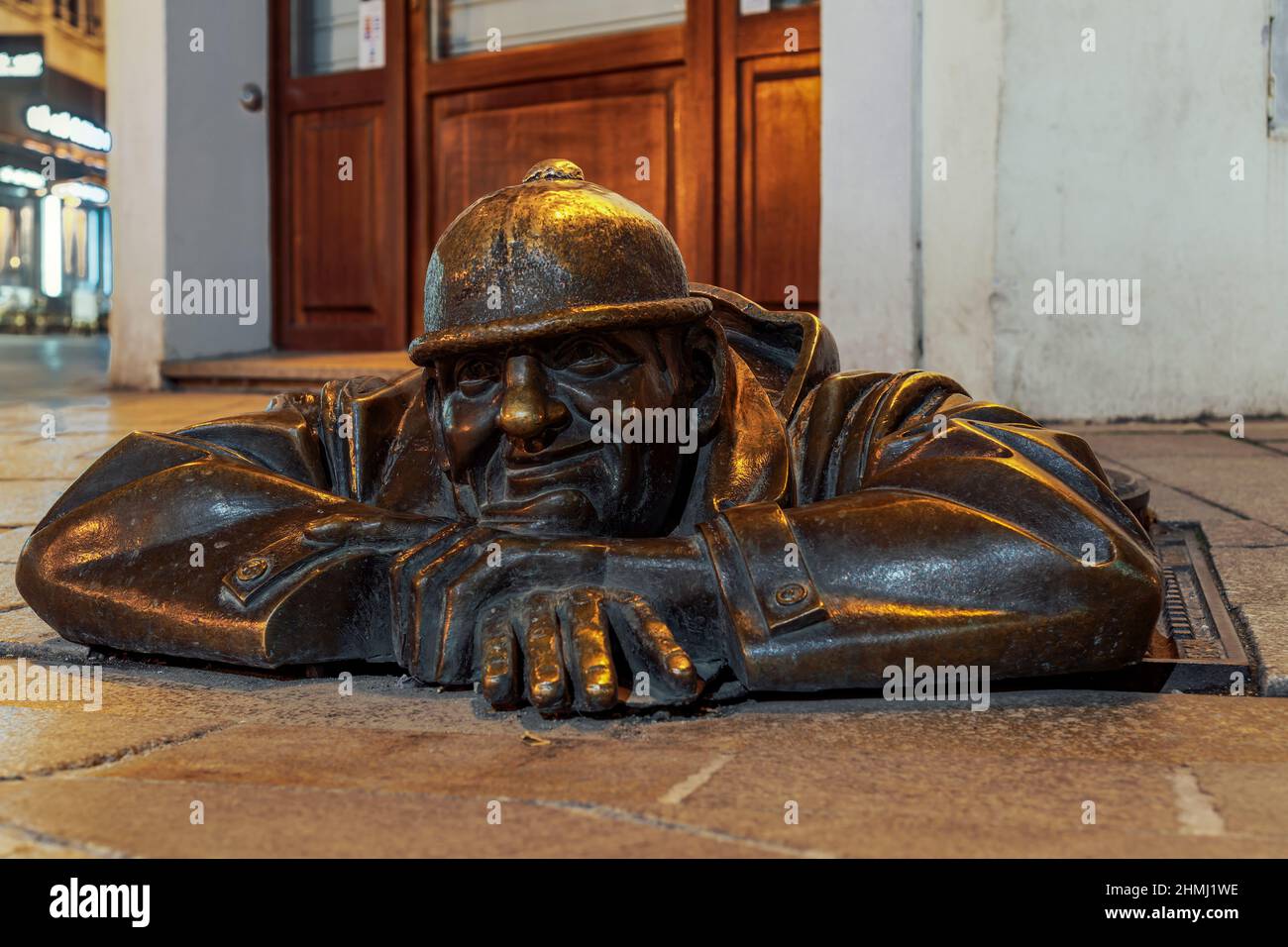 Bratislava, Slovakia low angle of Cumil statue looking at passing crowd ...