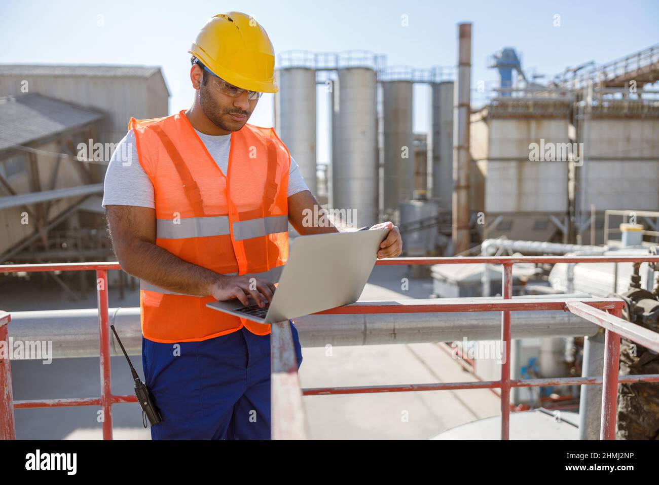 Multiethnic engineer working with laptop at plant Stock Photo - Alamy