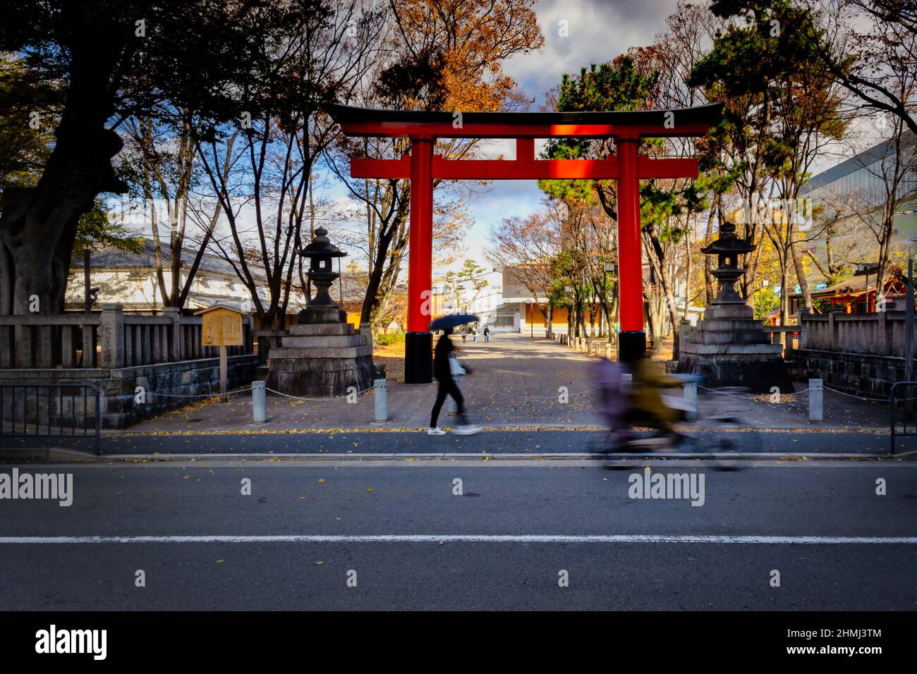 People pass the torii gate that stands in front of the Inariokami ...
