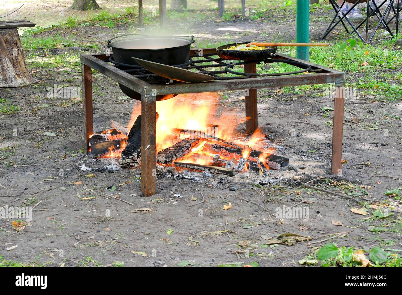 Kazan on an open fire on a metal grill for cooking pilaf on a tourist ...