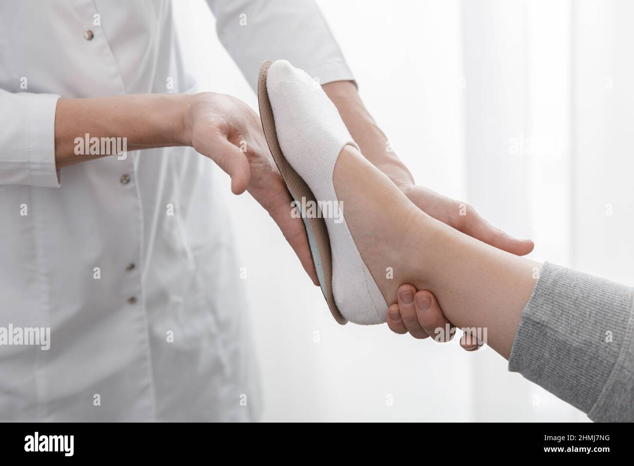 Doctor hands hold an orthopedic insole. Orthopedist tests the medical ...