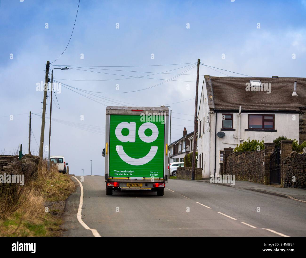 An AO delivery van on West Yorkshire lane heads up the hill to deliver ...