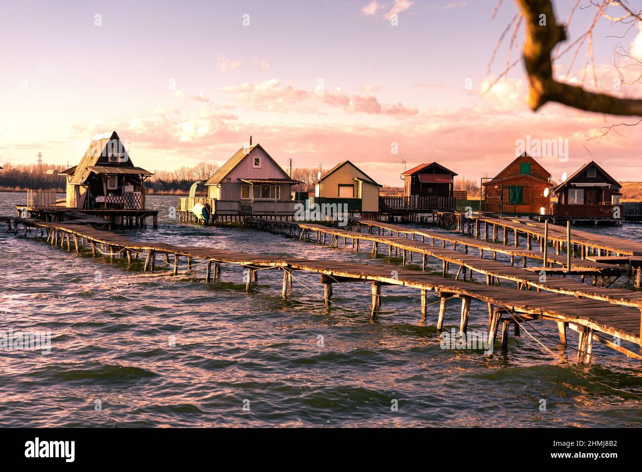 sunset on floating village bungalows in Bokod Hungary with wooden pier ...